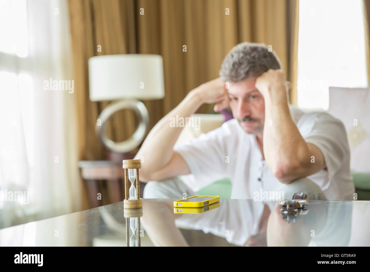 middle aged man looking at his phone longingly Stock Photo - Alamy