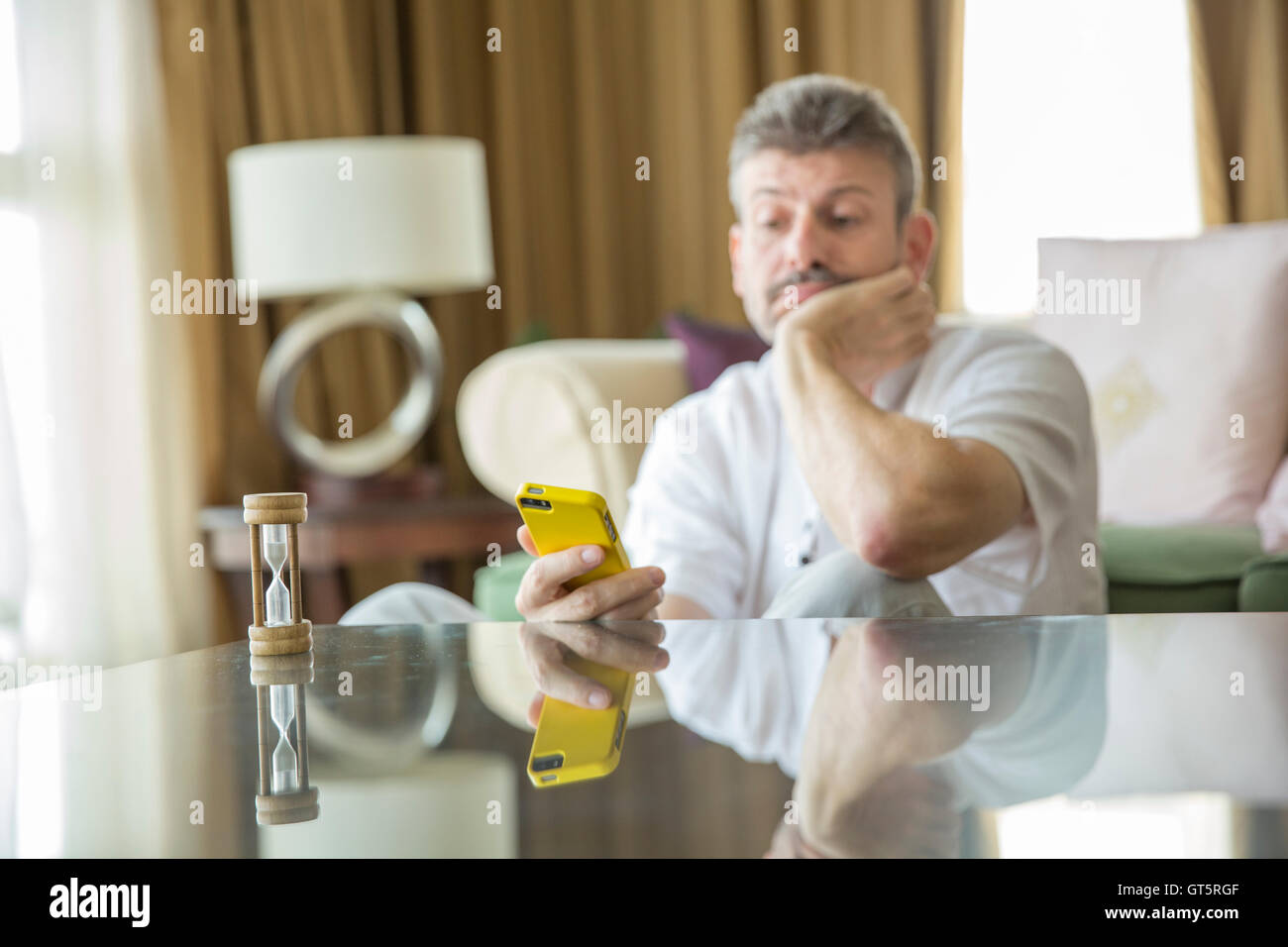 middle aged man looking at his phone longingly Stock Photo - Alamy
