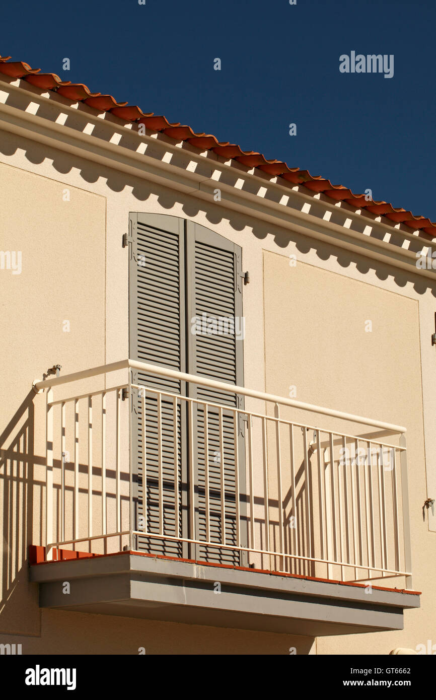 Closed shuttered windows on a whitewashed house in the sun Stock Photo ...