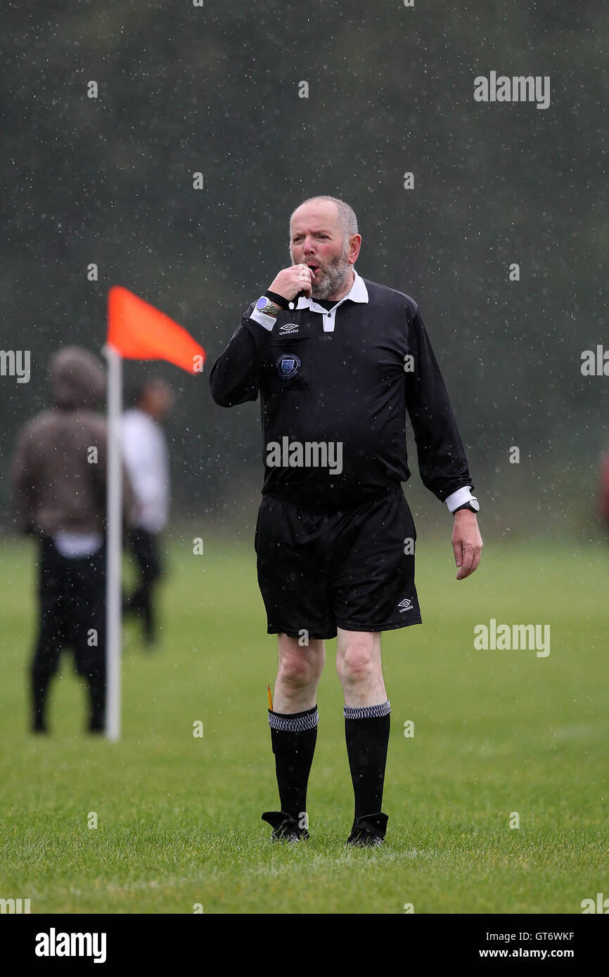 A match referee blows his whistle during a Sunday football match at ...