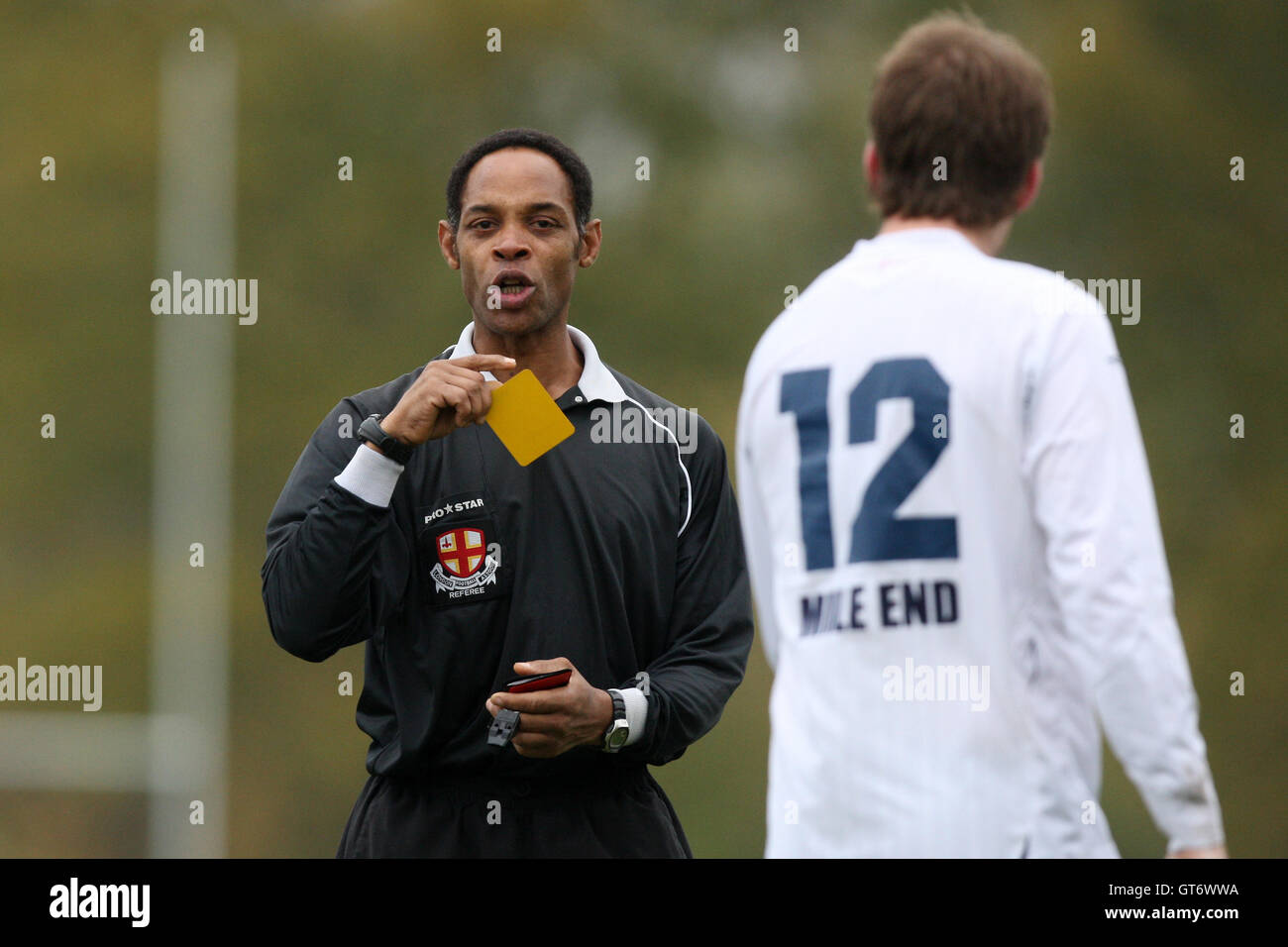 The match referee shows a yellow card to a Mile End player during a ...