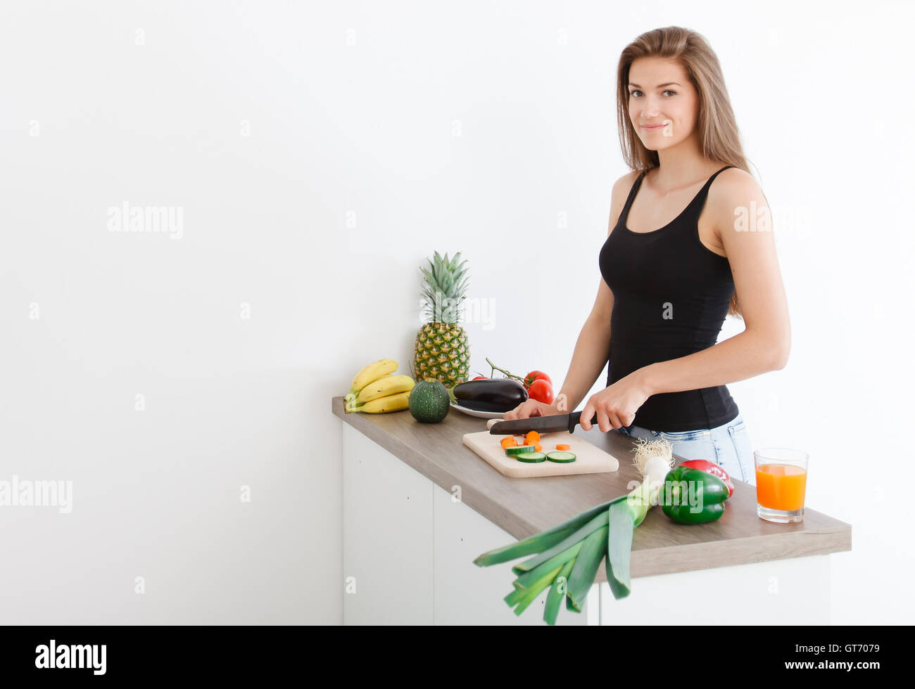 long-haired young woman prepares a modern, stylish kitchen healthy ...
