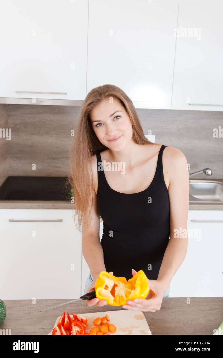 long-haired young woman prepares a modern, stylish kitchen healthy ...