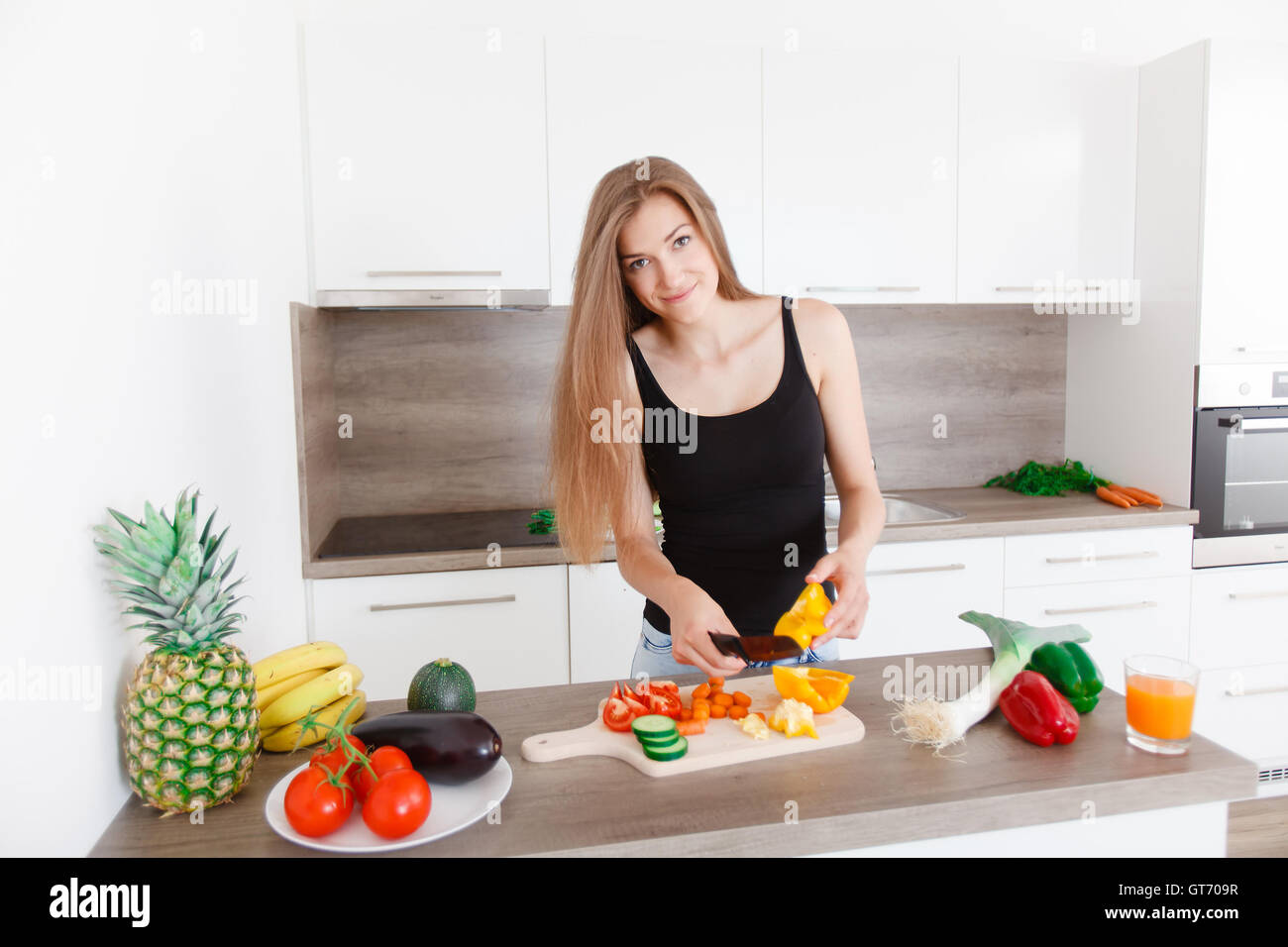 long-haired young woman prepares a modern, stylish kitchen healthy ...