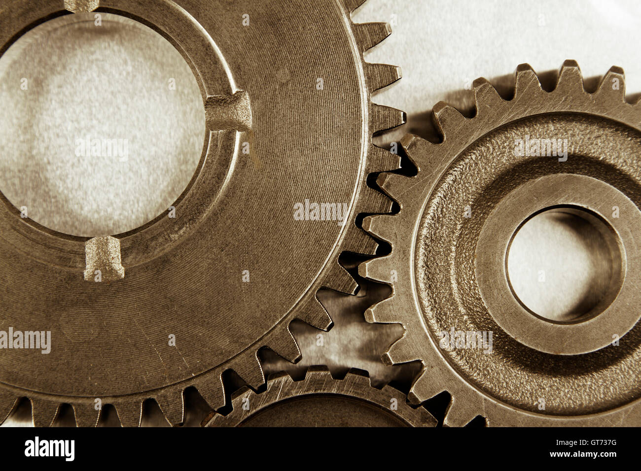Metal cog gears joining together Stock Photo - Alamy