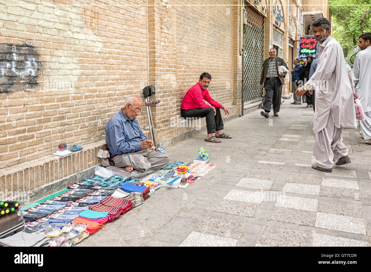 One-legged man selling items on the sidewalk in Yazd, Iran Stock Photo ...