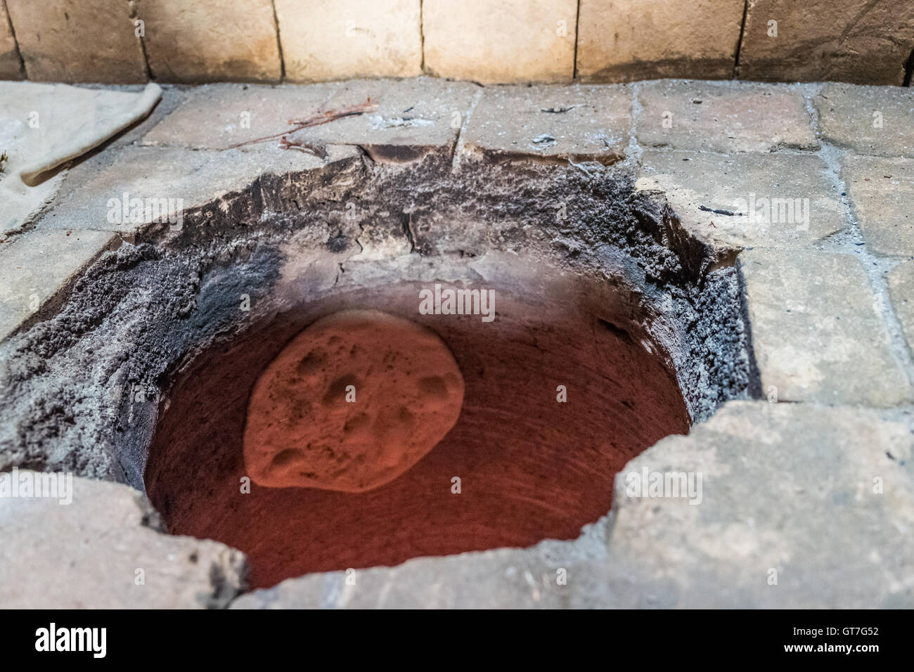 Taftoon bread baking in tandoori oven in traditional restaurant run by ...