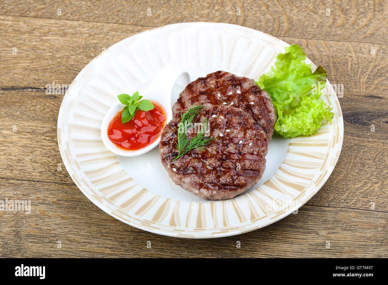 Grilled burger cutlet with onion and salad leaves Stock Photo - Alamy