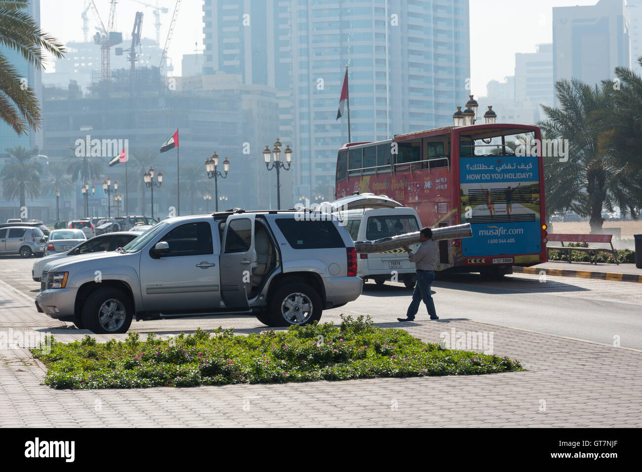 Man loading a carpet into a car outside The Central Souk, Sharjah, UAE ...