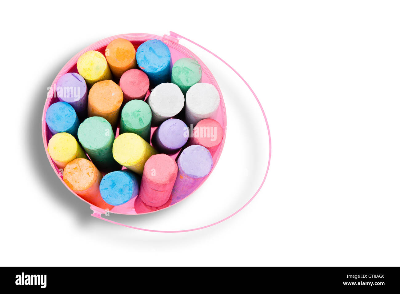 Pink bucket of colorful chalk crayons viewed from above isolated on ...