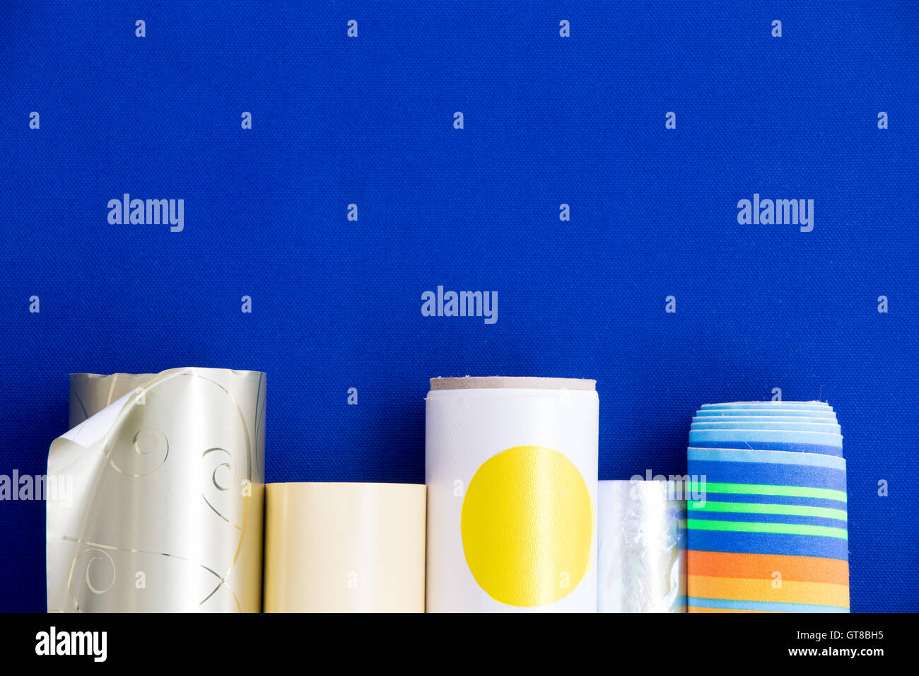 Colorful rolls of decorative patterned gift wrap in a bottom border ...