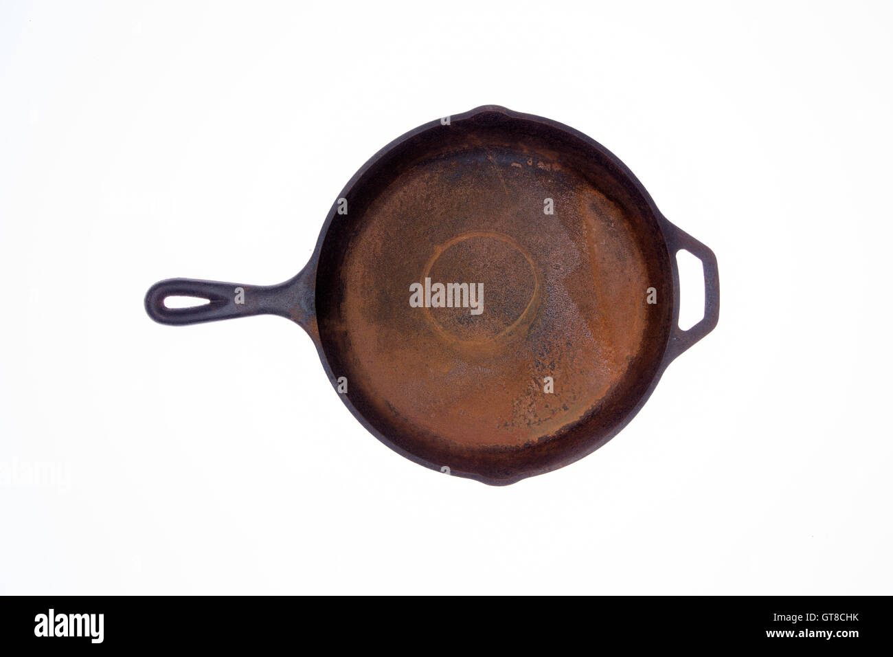 Old rusty round black cast iron frying pan viewed from above isolated ...
