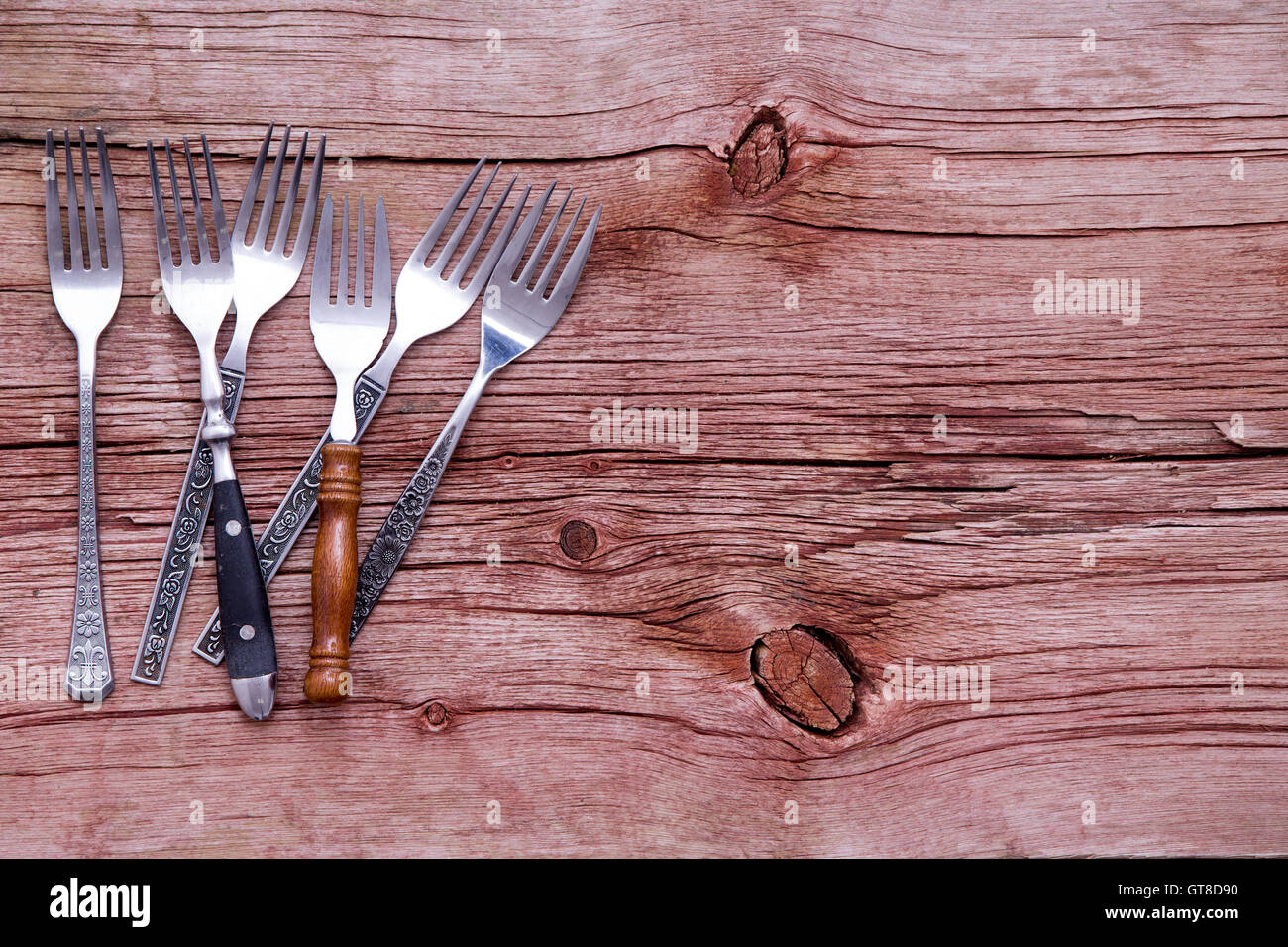 Random pile of assorted rustic forks arranged on the side of a rustic ...