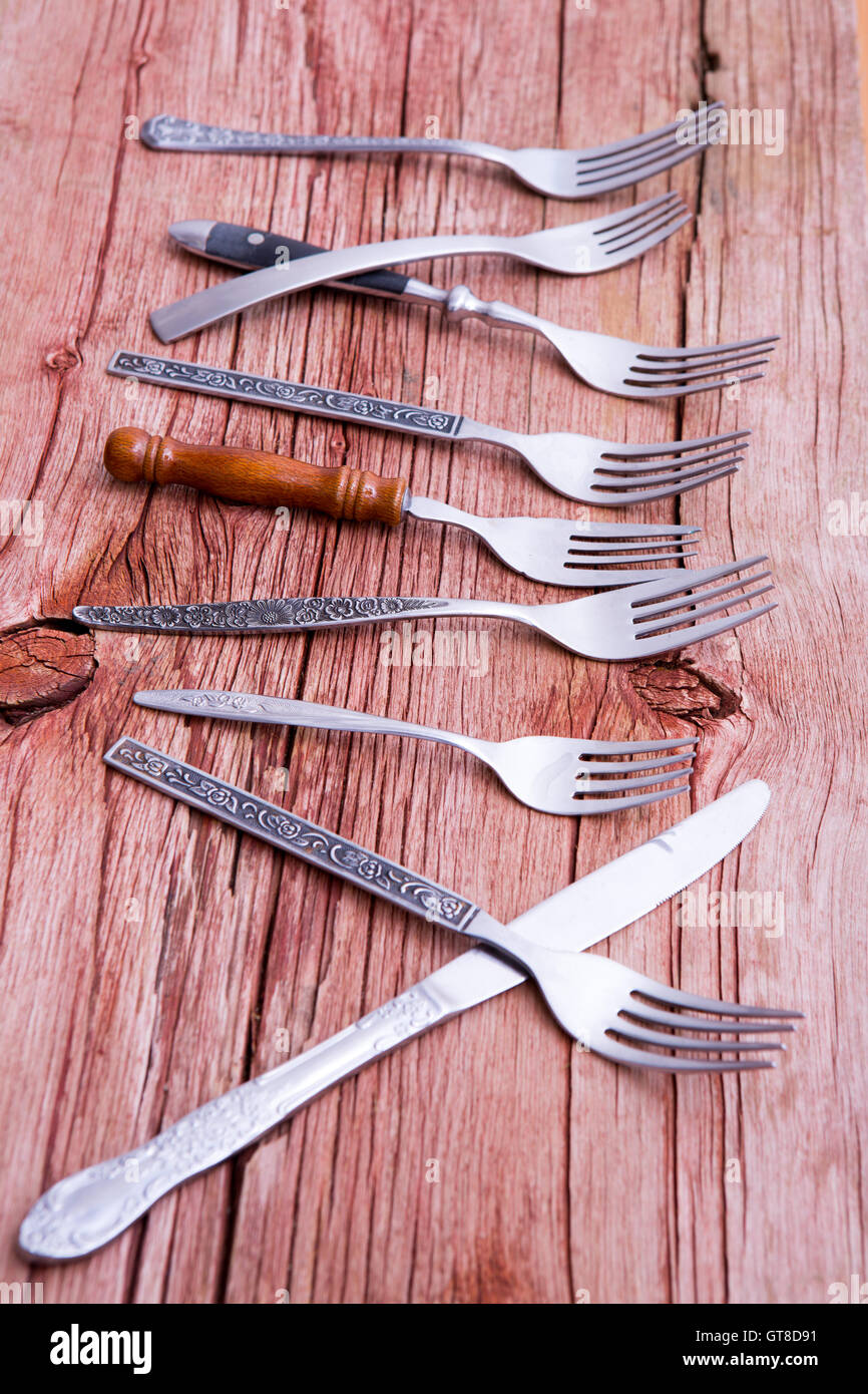 Array of rustic forks and a single knife arranged randomly in a ...
