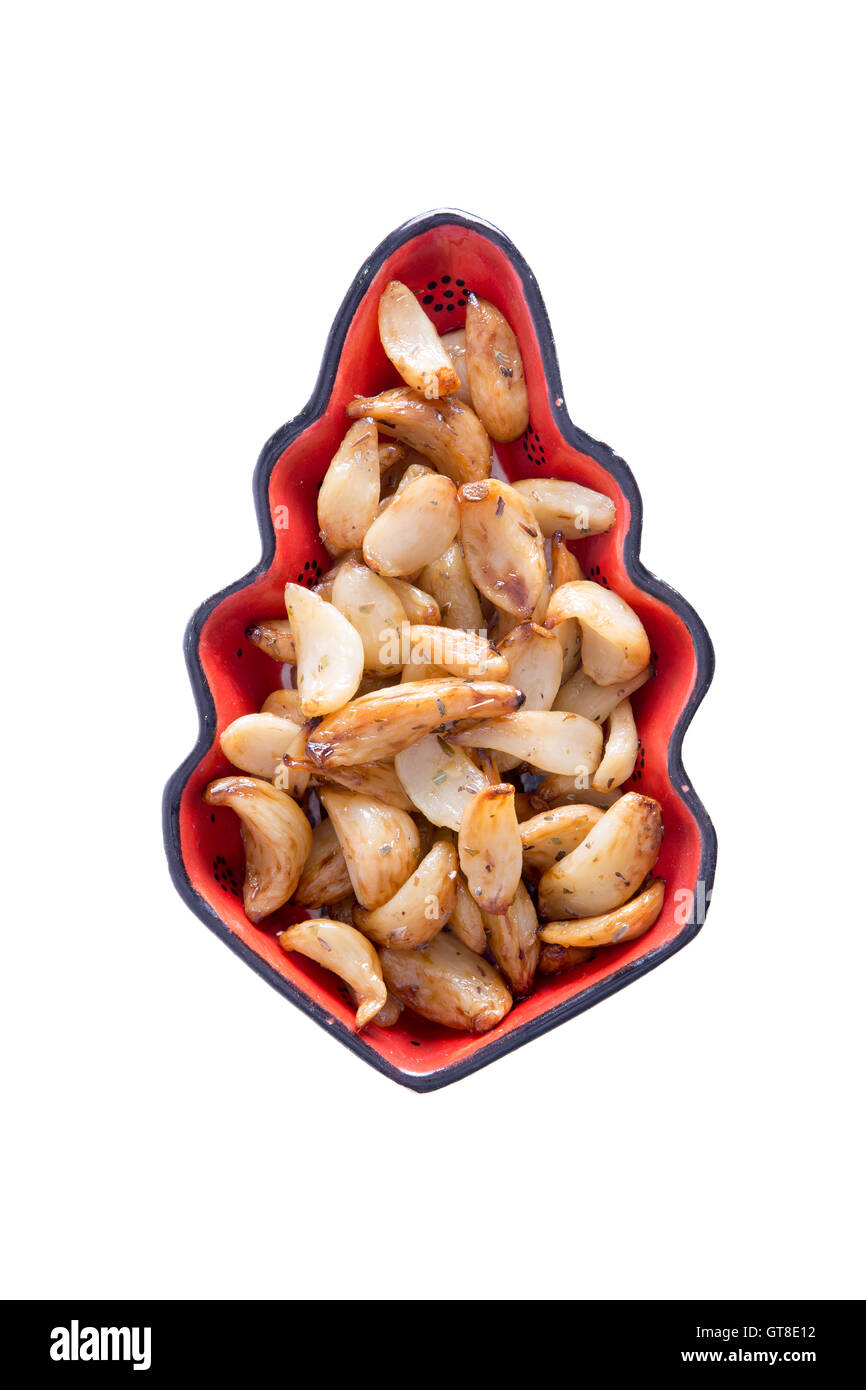 Roasted spicy marinated garlic cloves in a decorative leaf-shaped ...