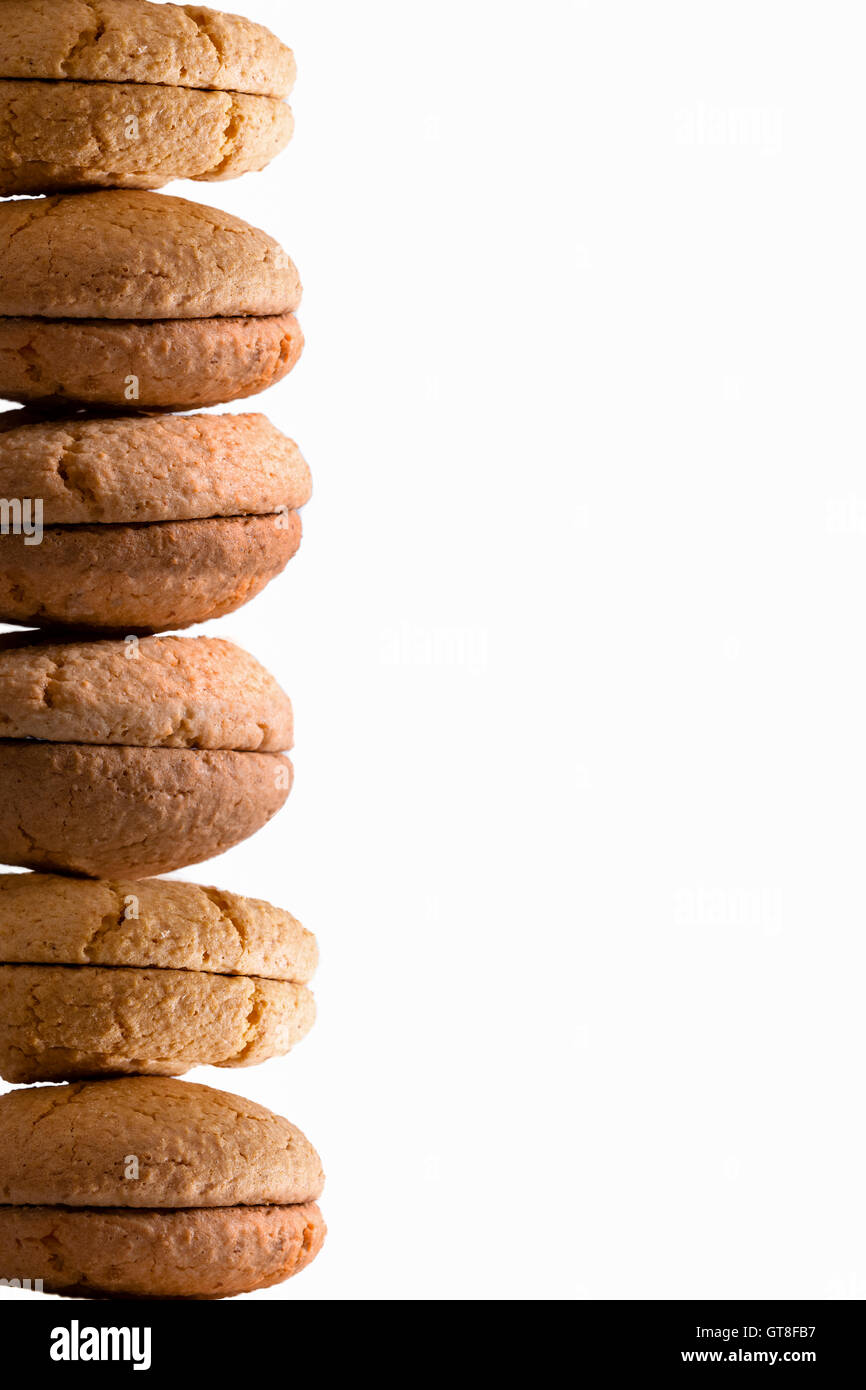 Food border of stacked freshly baked macaroons over a white background ...