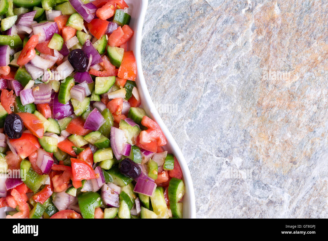 Colorful fresh Turkish shepherd salad served in a modern wavy dish over ...