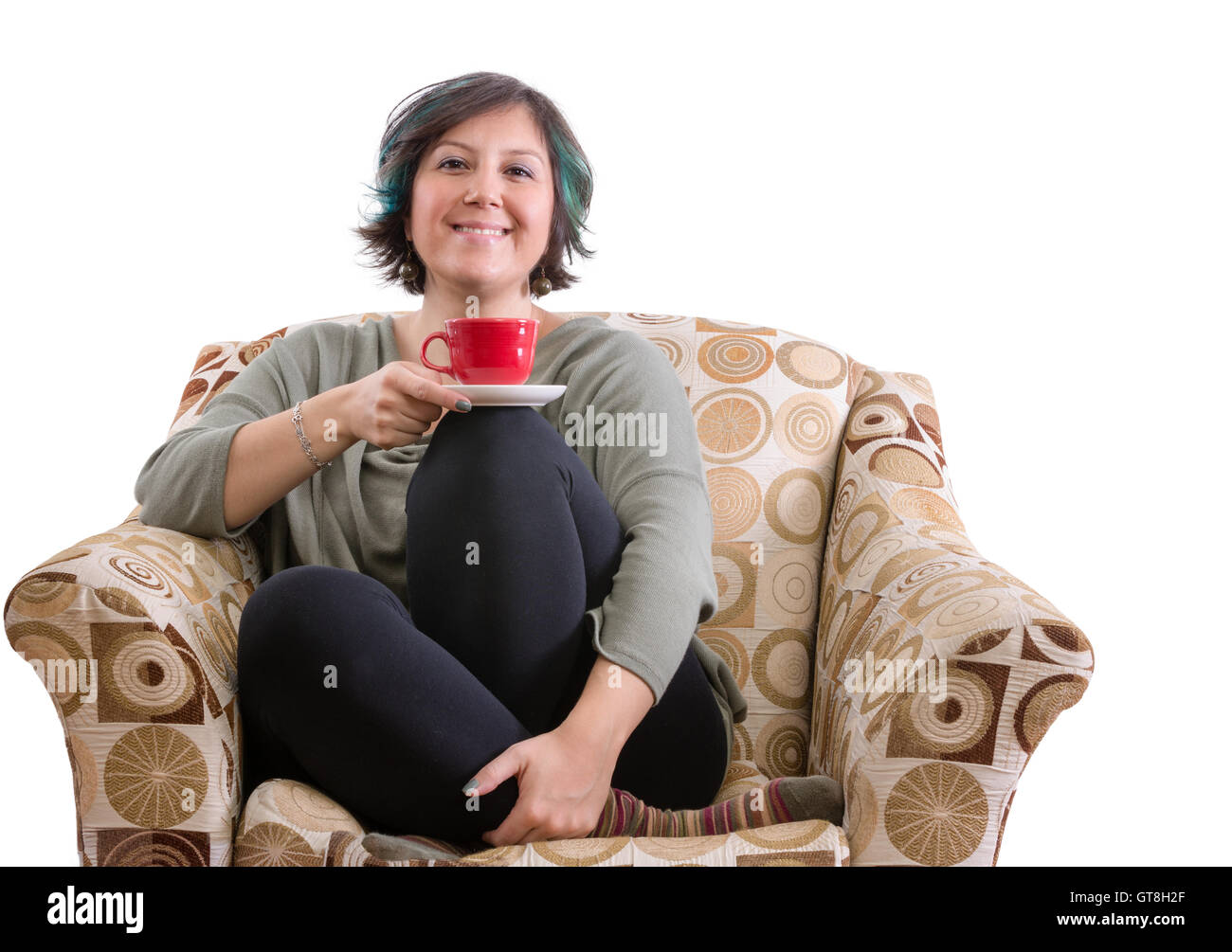Single adult woman with smile sitting with red mug and crossed legs in ...