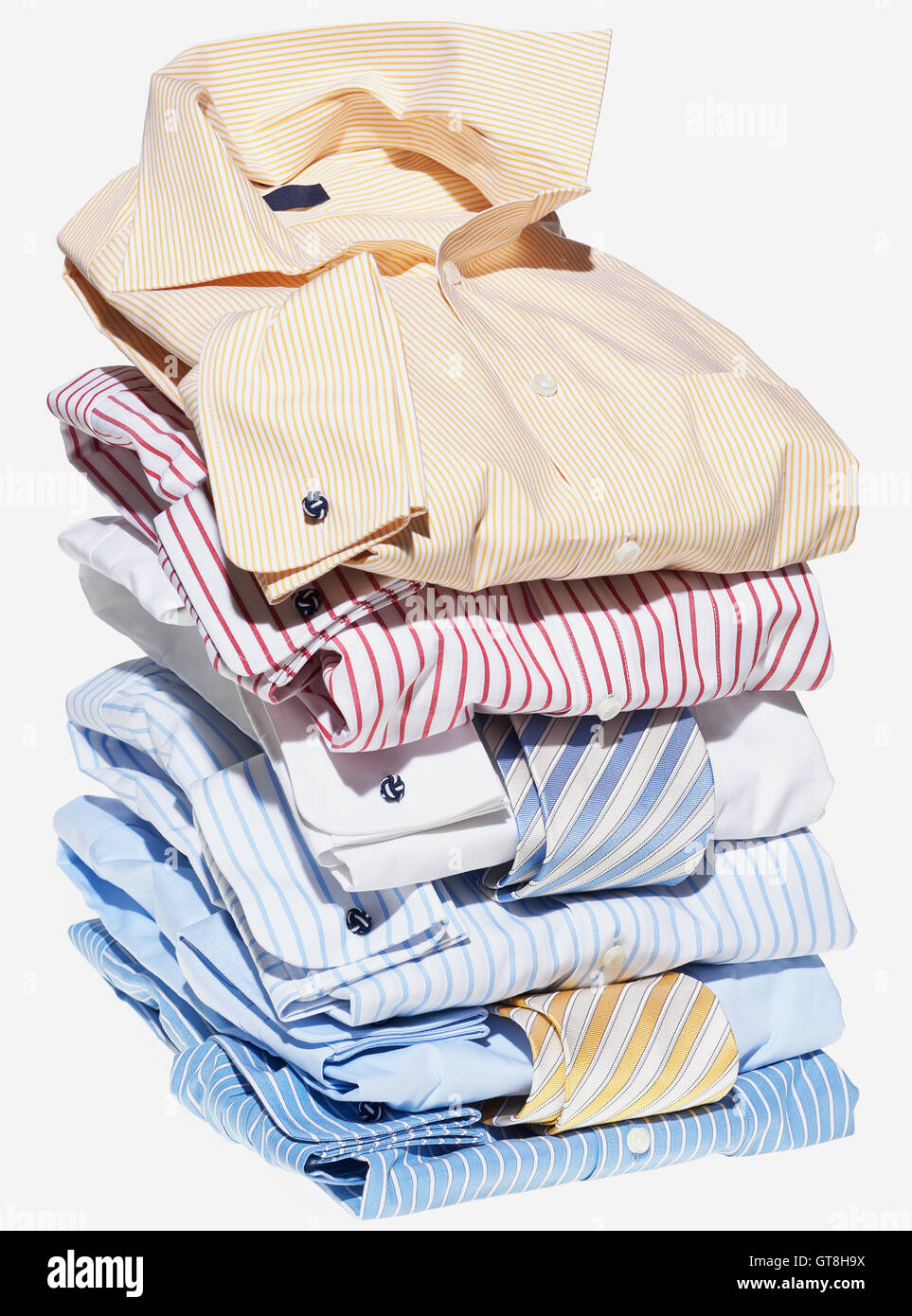 Stack of multi coloured shirts with ties on white background Stock ...