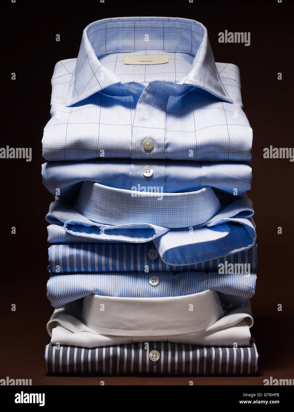 Stack of men's dress shirts on black background Stock Photo - Alamy