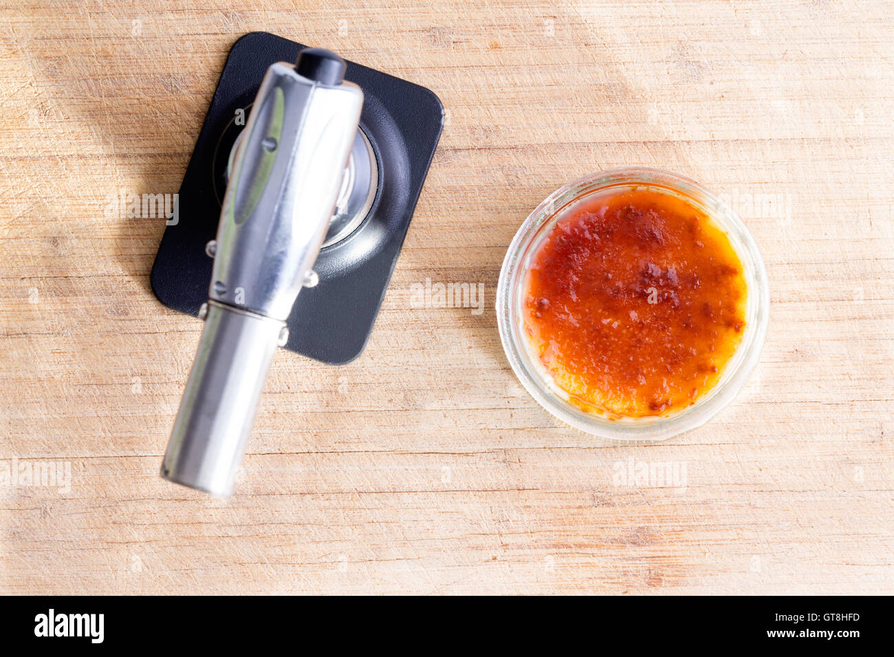 Freshly made creme brulee with a butane torch for caramelizing the ...