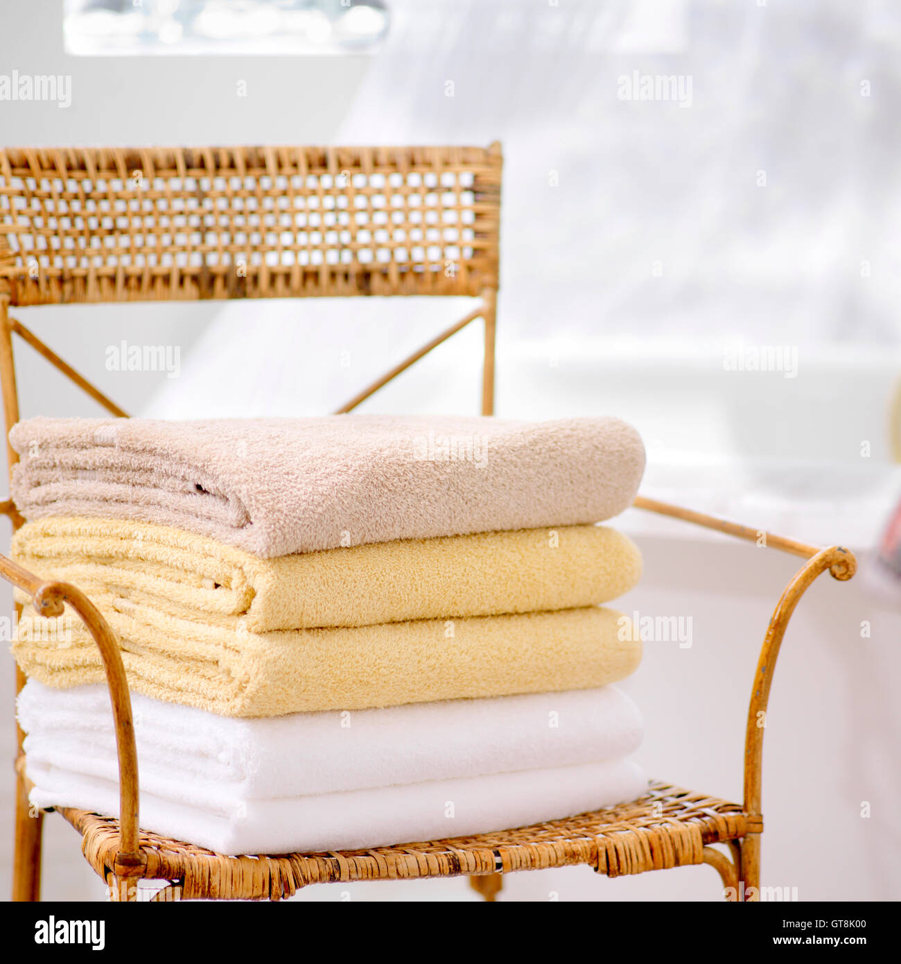 Stack of Fresh Towels on Wicker Chair in Bathroom Stock Photo - Alamy