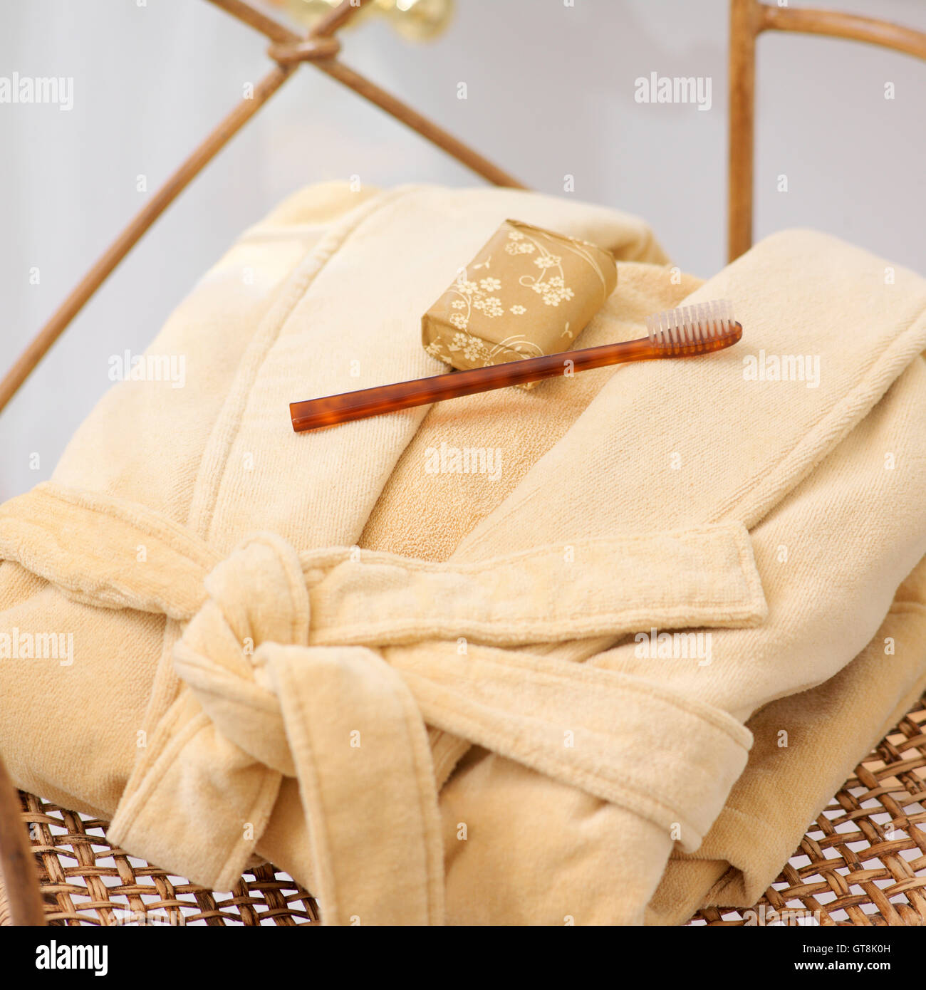 Folded Robe with Soap and Toothbrush on Wicker Chair Stock Photo - Alamy