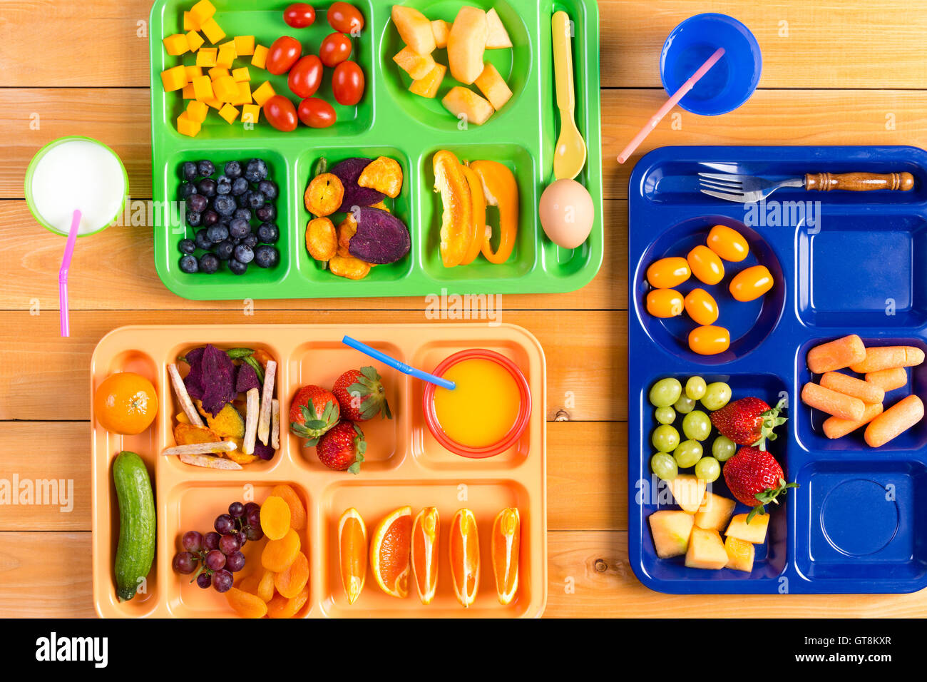 Top down view of colorful plastic lunch trays filled with slices and ...