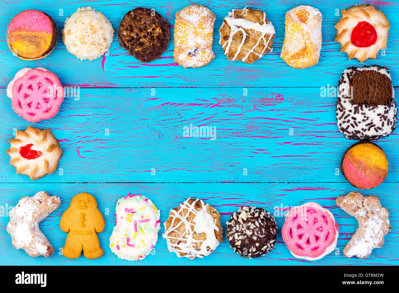 Rectangular frame of colorful assorted cookies or biscuits on a blue ...