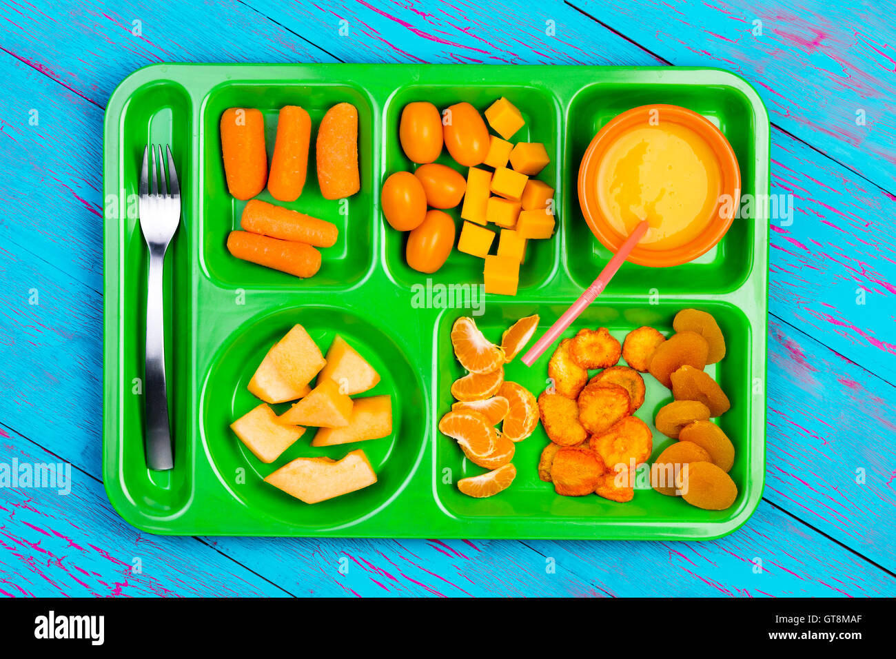 Various fresh and dried fruit cut into small pieces and cup of juice in ...