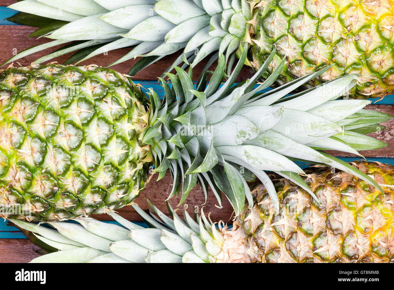 Three large pineapple fruits placed closely next to each other in ...