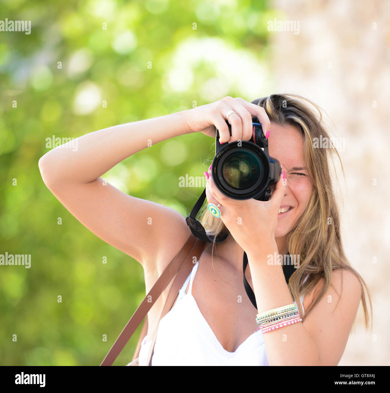 Happy woman photographer holding a dslr camera Stock Photo - Alamy
