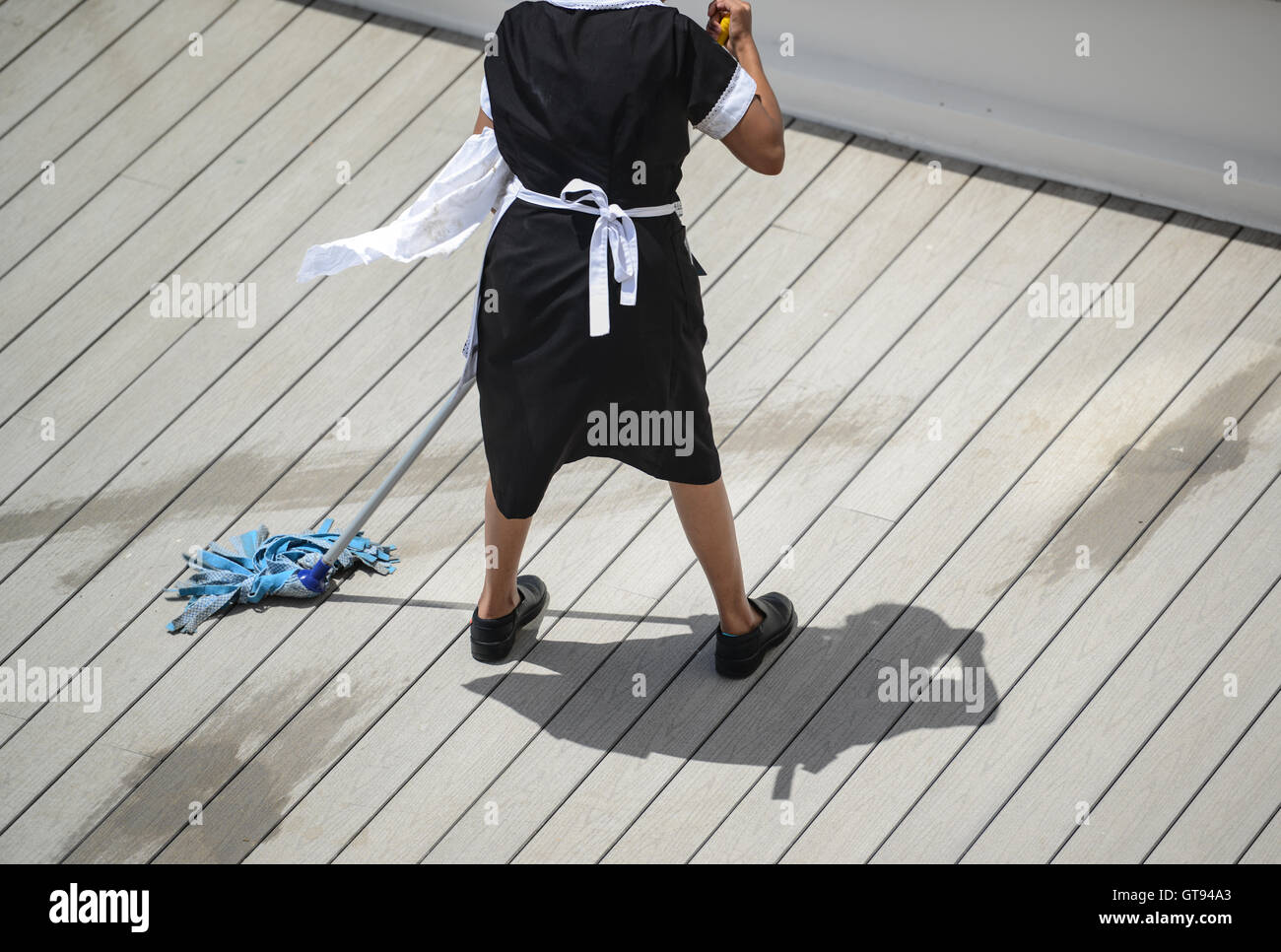 Maid with mop and in uniform cleaning floor Stock Photo - Alamy