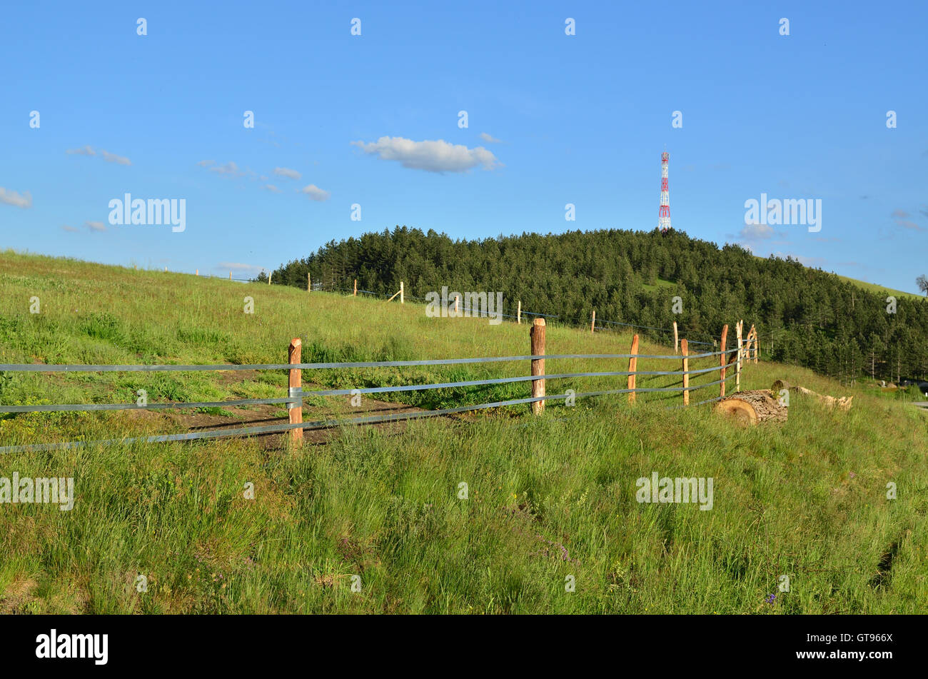 Landscape image of countryside with field of green grass, fence, blue ...