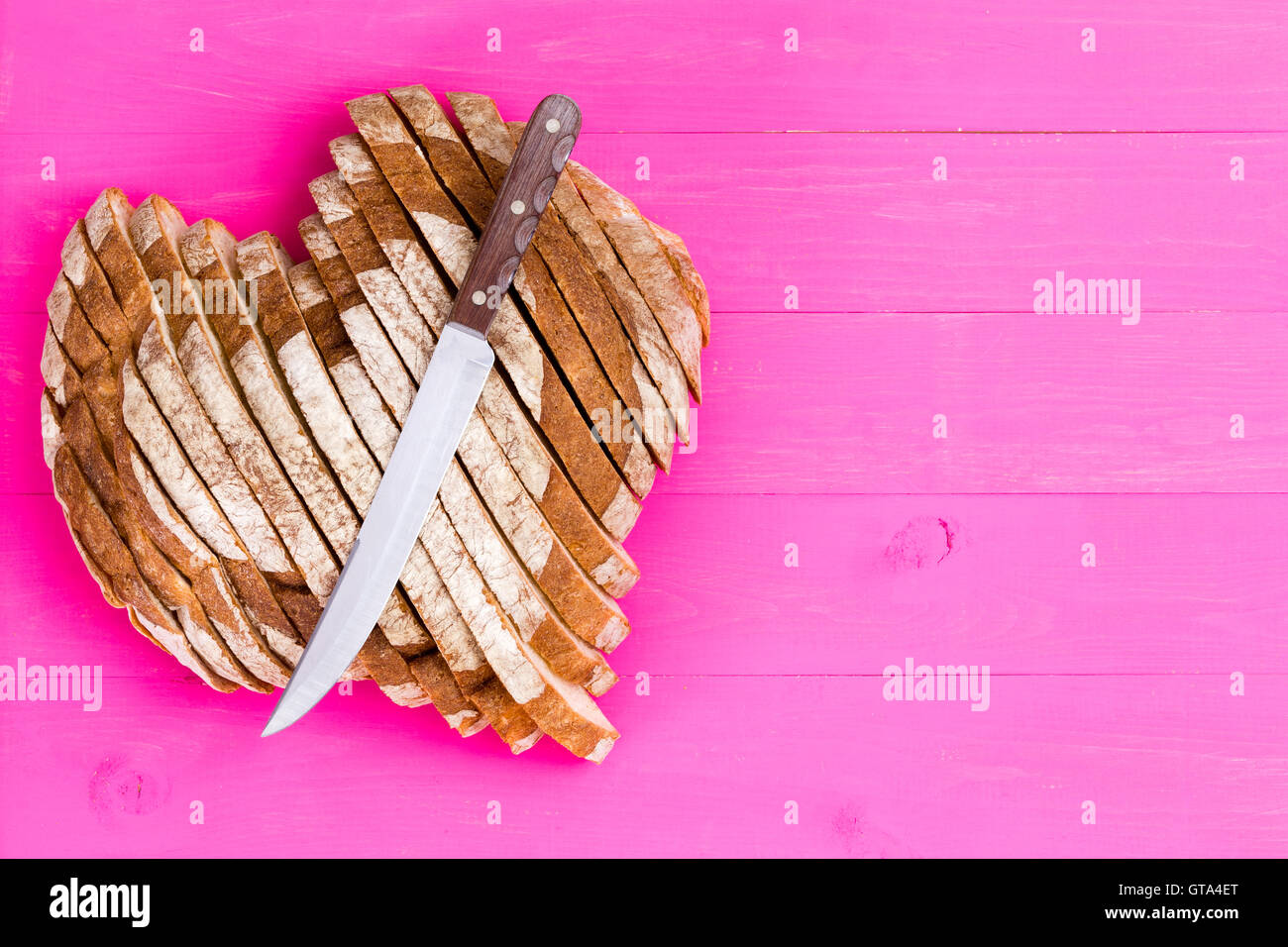 Top down view of freshly baked and sliced heart shaped bread with sharp ...