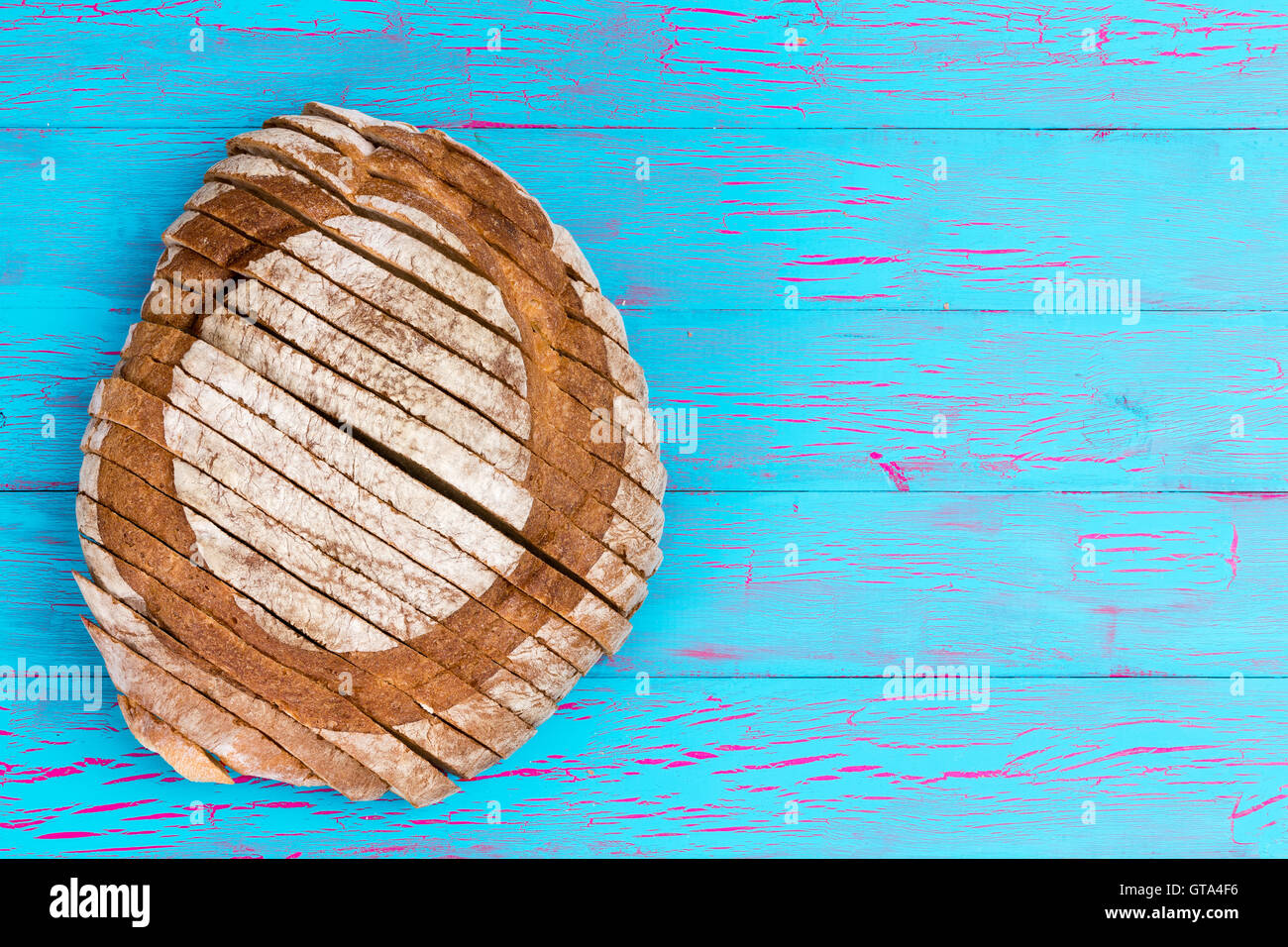 Circular shaped delicious homemade sliced bread loaf on crackled blue ...