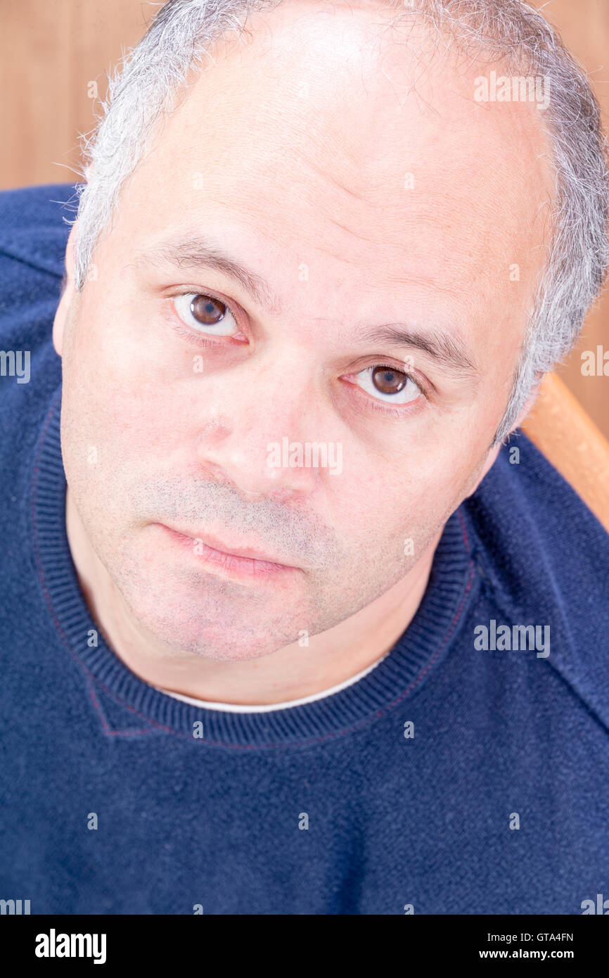 Overhead view of older man looking upwards into the camera while ...