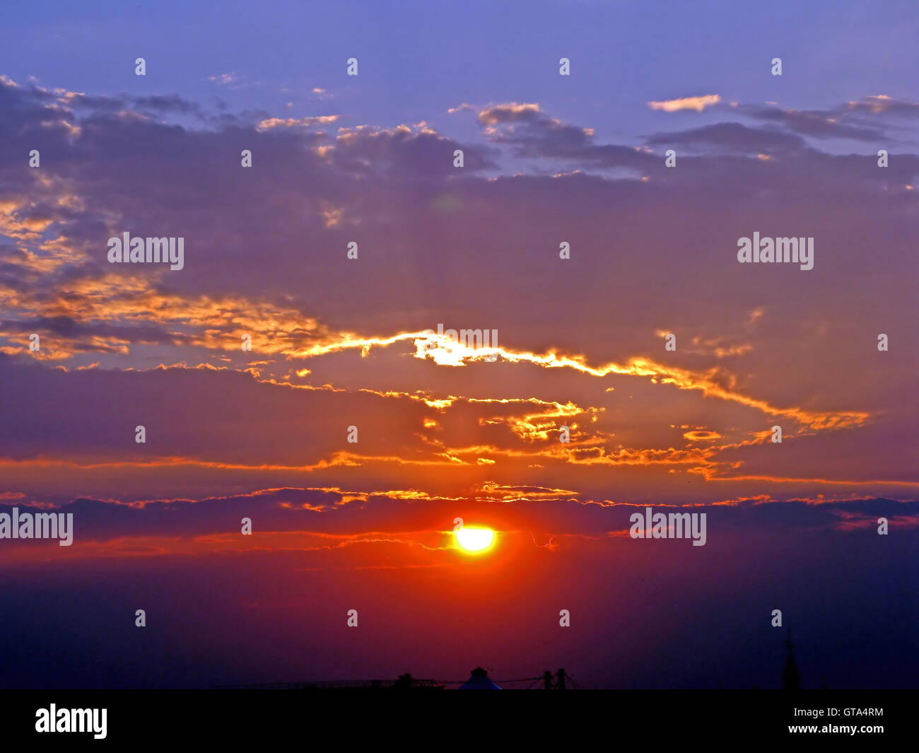 A red, blue and golden burning sunset Stock Photo - Alamy