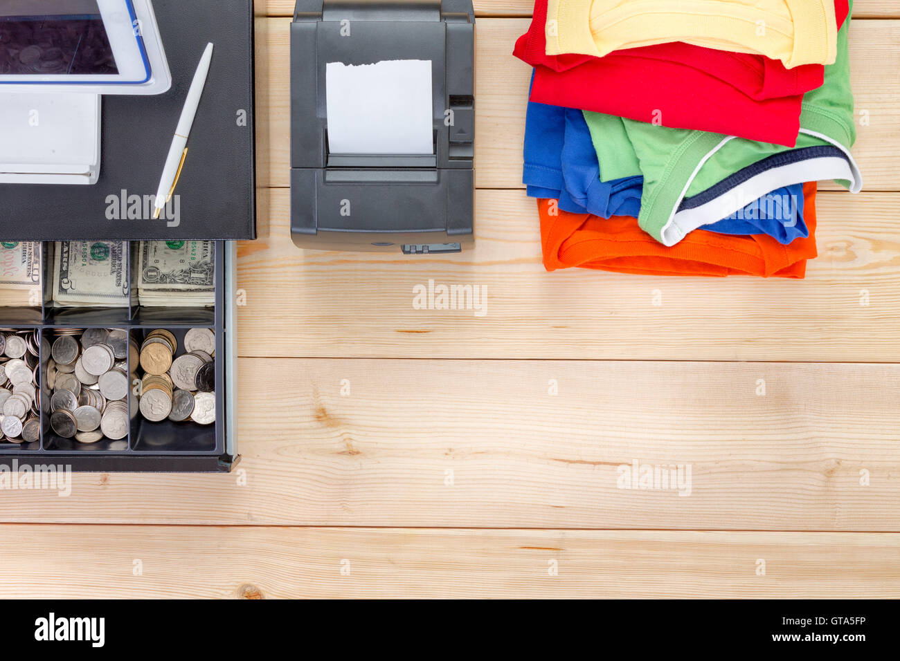 Neatly folded pile of brightly colored summer clothes, an adding ...