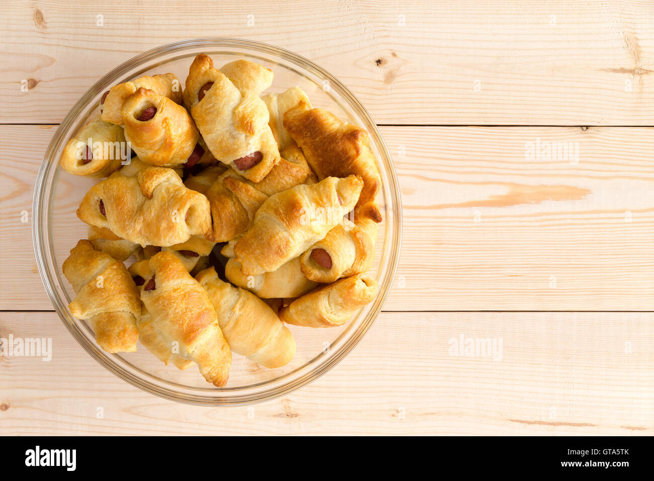 Glass plate heaped with fresh hot dog croissants filled with a spicy ...