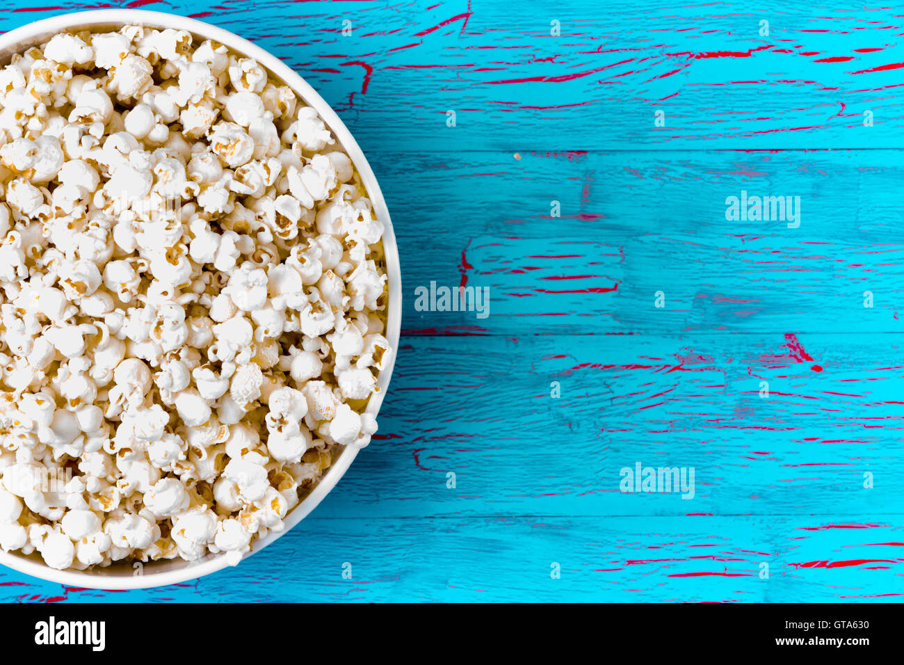 Bowl of freshly made popcorn on a colorful blue crackle paint picnic ...