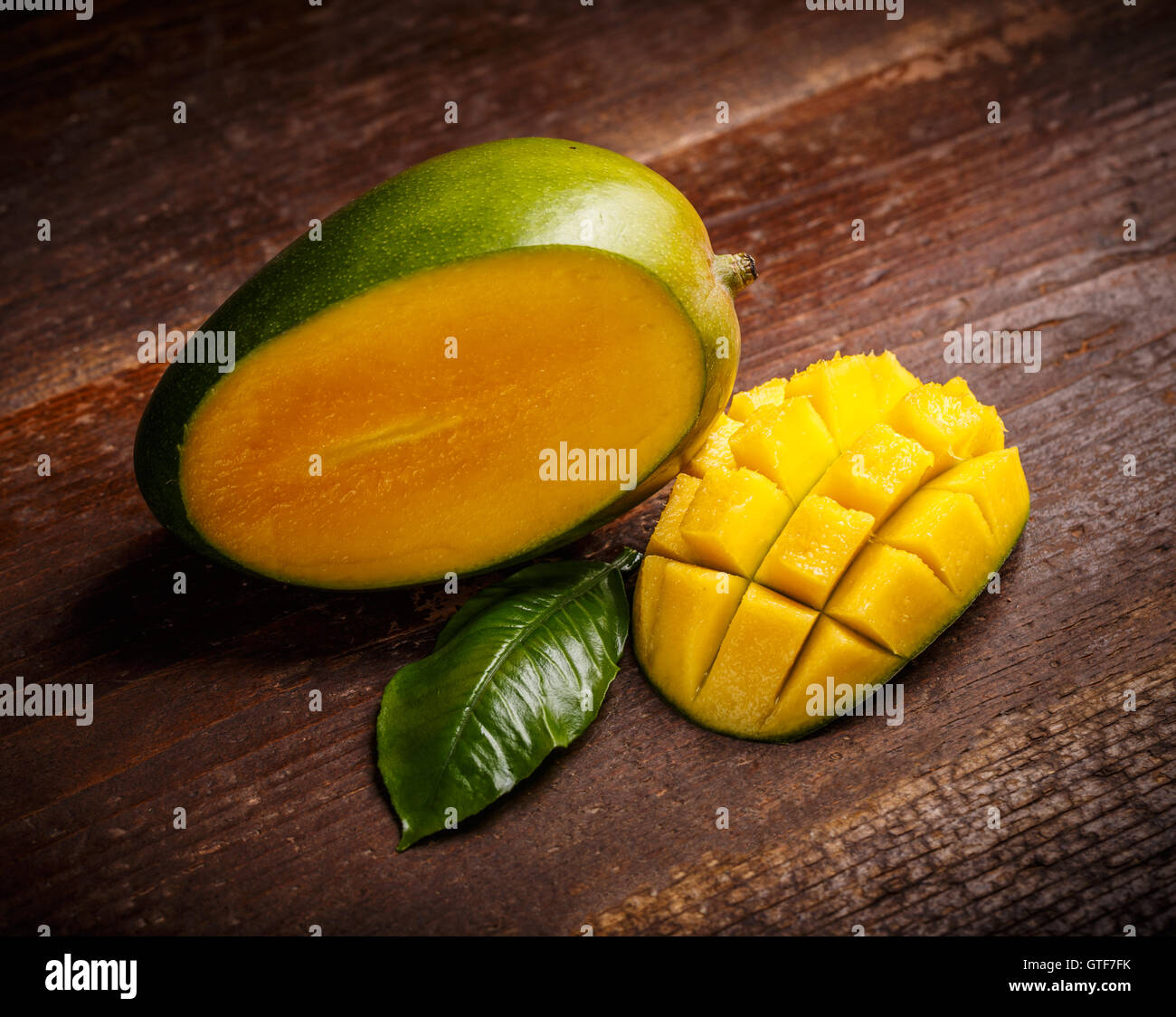 Mango fruit and mango cubes on wooden background Stock Photo - Alamy