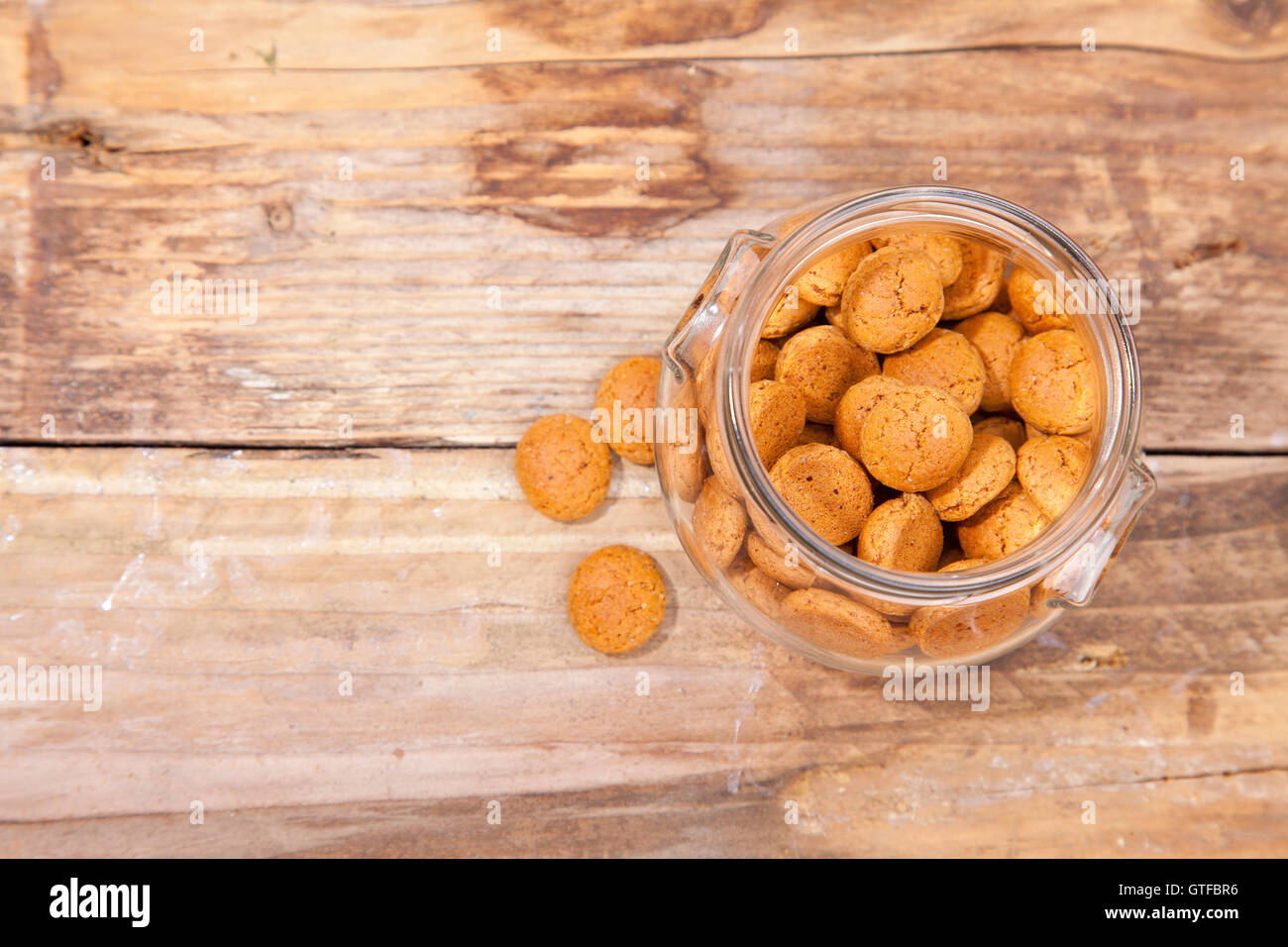 Traditional Dutch candy pepernoot in glass jar on wooden background ...
