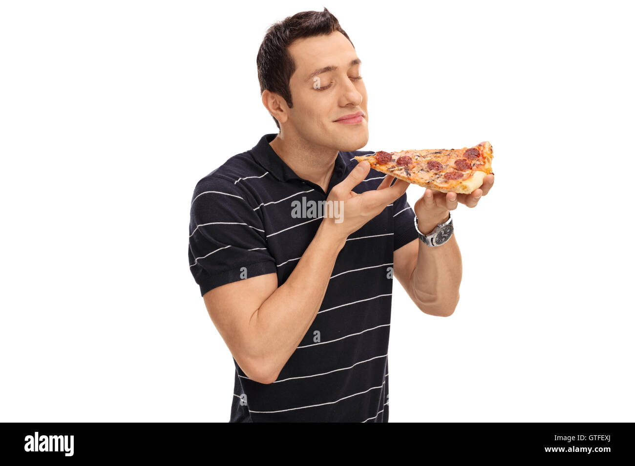 Young man smelling a slice of pizza isolated on white background Stock ...