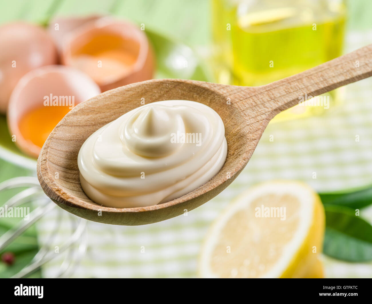 Natural mayonnaise sauce in the wooden spoon and its ingredient on the ...
