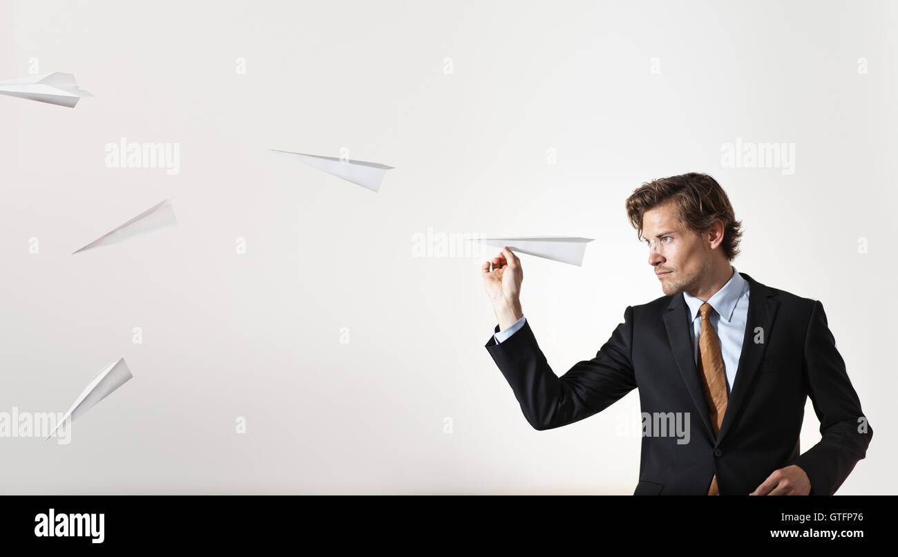 Businessman throwing paper airplanes at target Stock Photo - Alamy