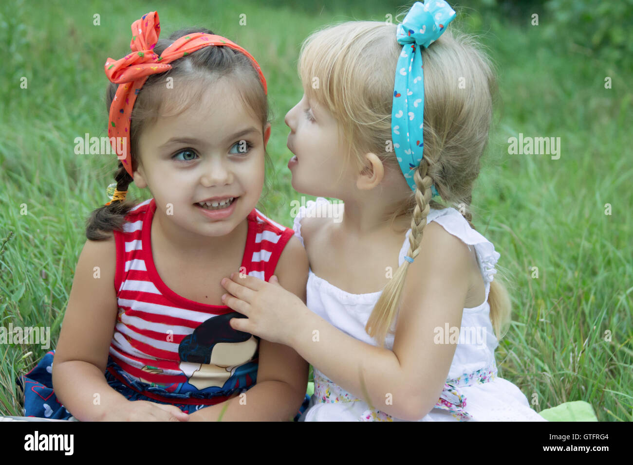 Two girls sharing secrets Stock Photo - Alamy