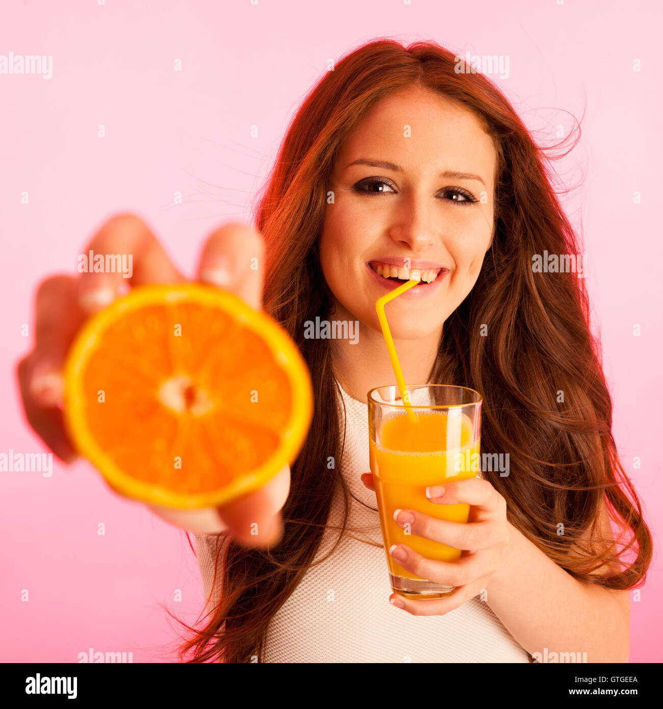 Woman drinking orange juice smiling showing oranges. Young beautiful ...