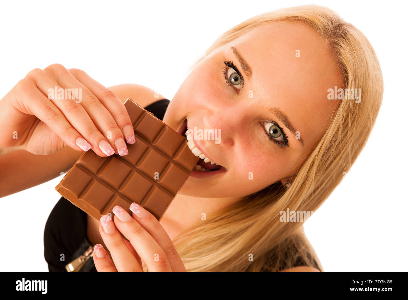 Beautiful young woman eats chocolate isolated over white background ...