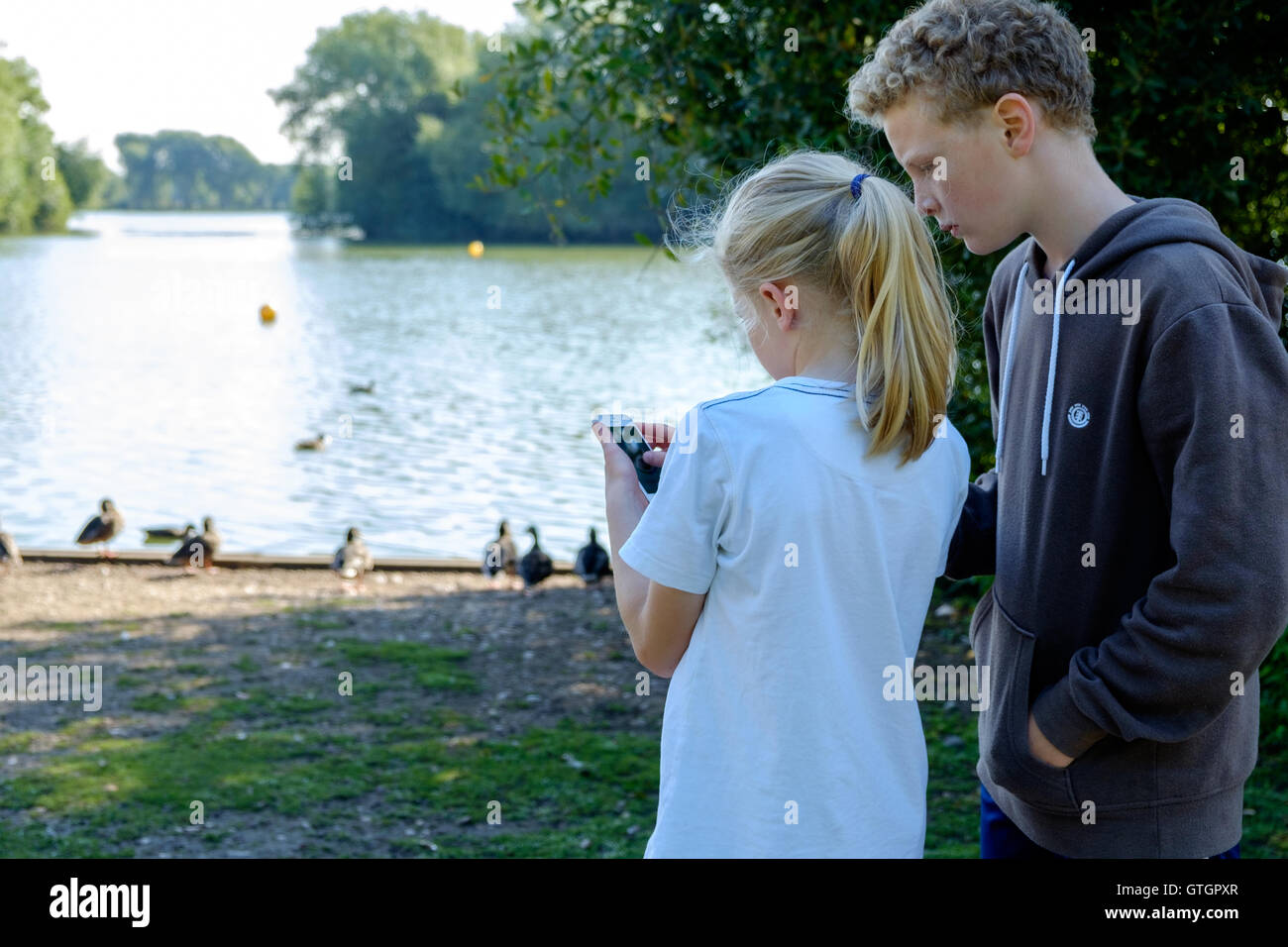 Two children playing Pokemon Go in the countryside Stock Photo - Alamy